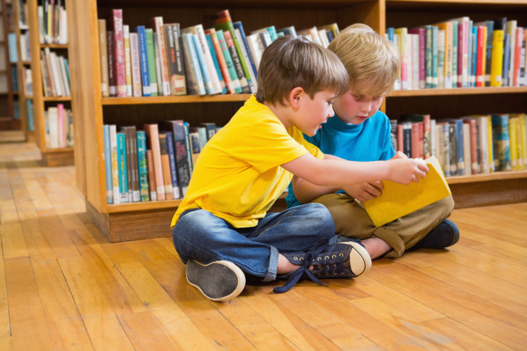 Pupils reading book at elementary school | Teacher Features